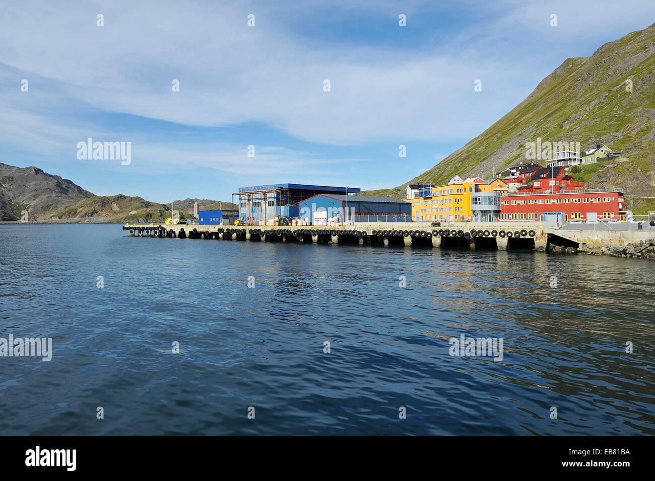 Concrete pier reinforced with tyres in front of coloured harbour ...