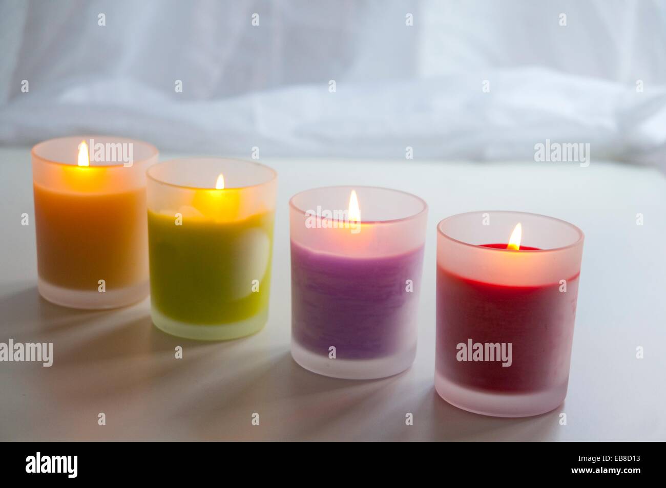 Four lit up candles Stock Photo - Alamy