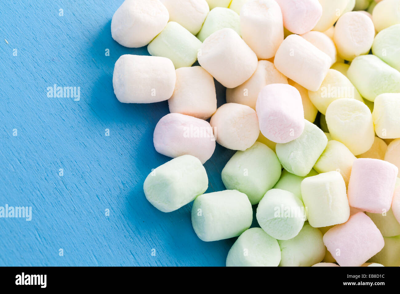Small round multicolor marshmallows on blue backgrouns Stock Photo - Alamy