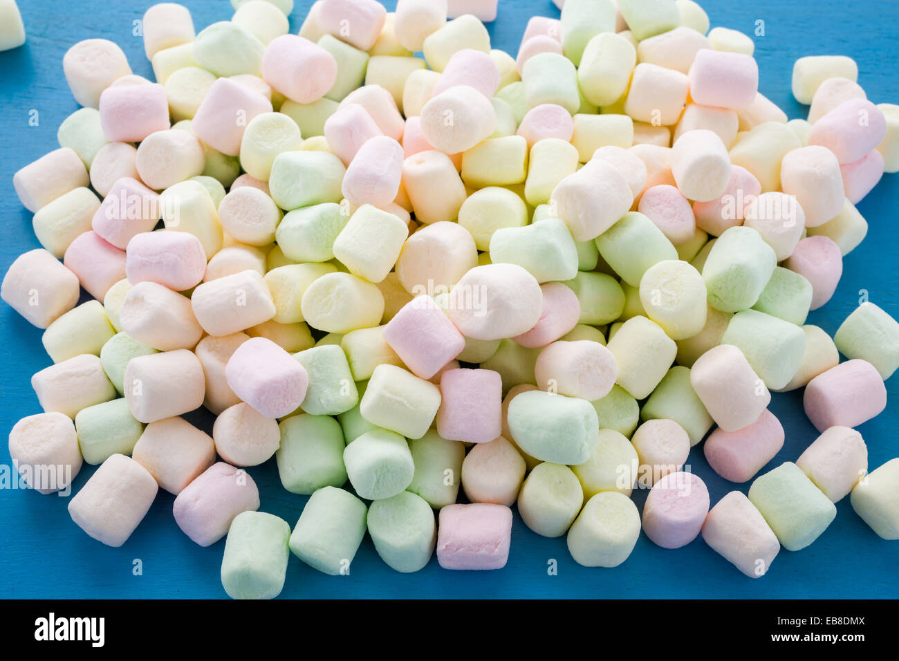 Small round multicolor marshmallows on blue backgrouns Stock Photo - Alamy