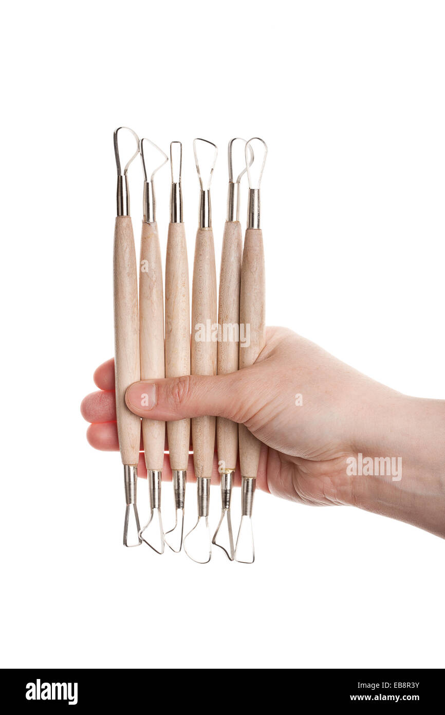 Pottery tools in hand isolated on white background Stock Photo - Alamy