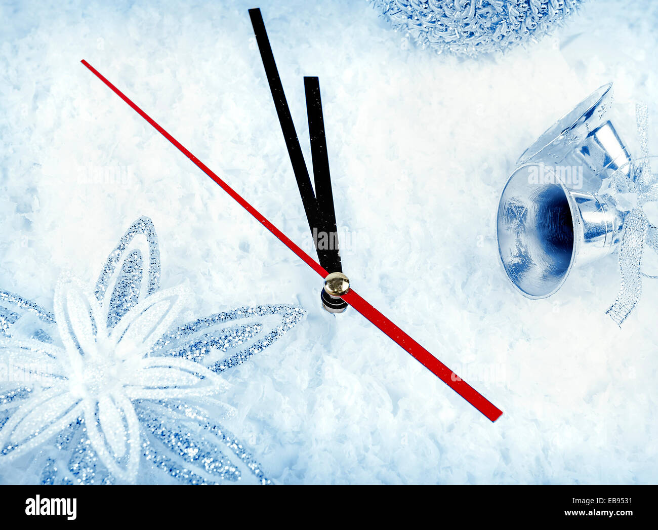 Clock with fir branches and Christmas decorations under snow close up ...