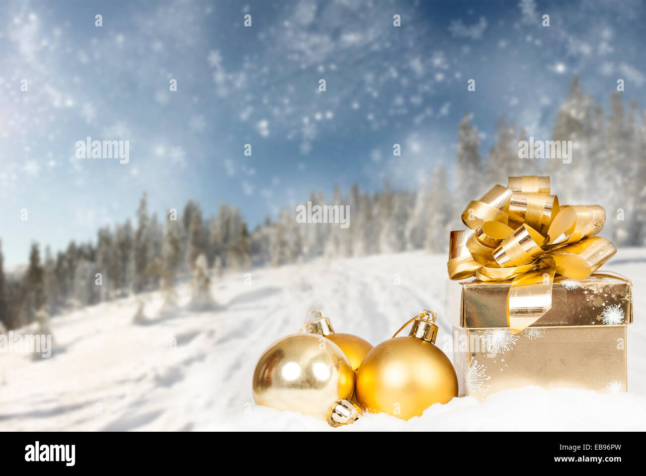 Christmas decorations and gift boxin front of snow cowered pine trees ...