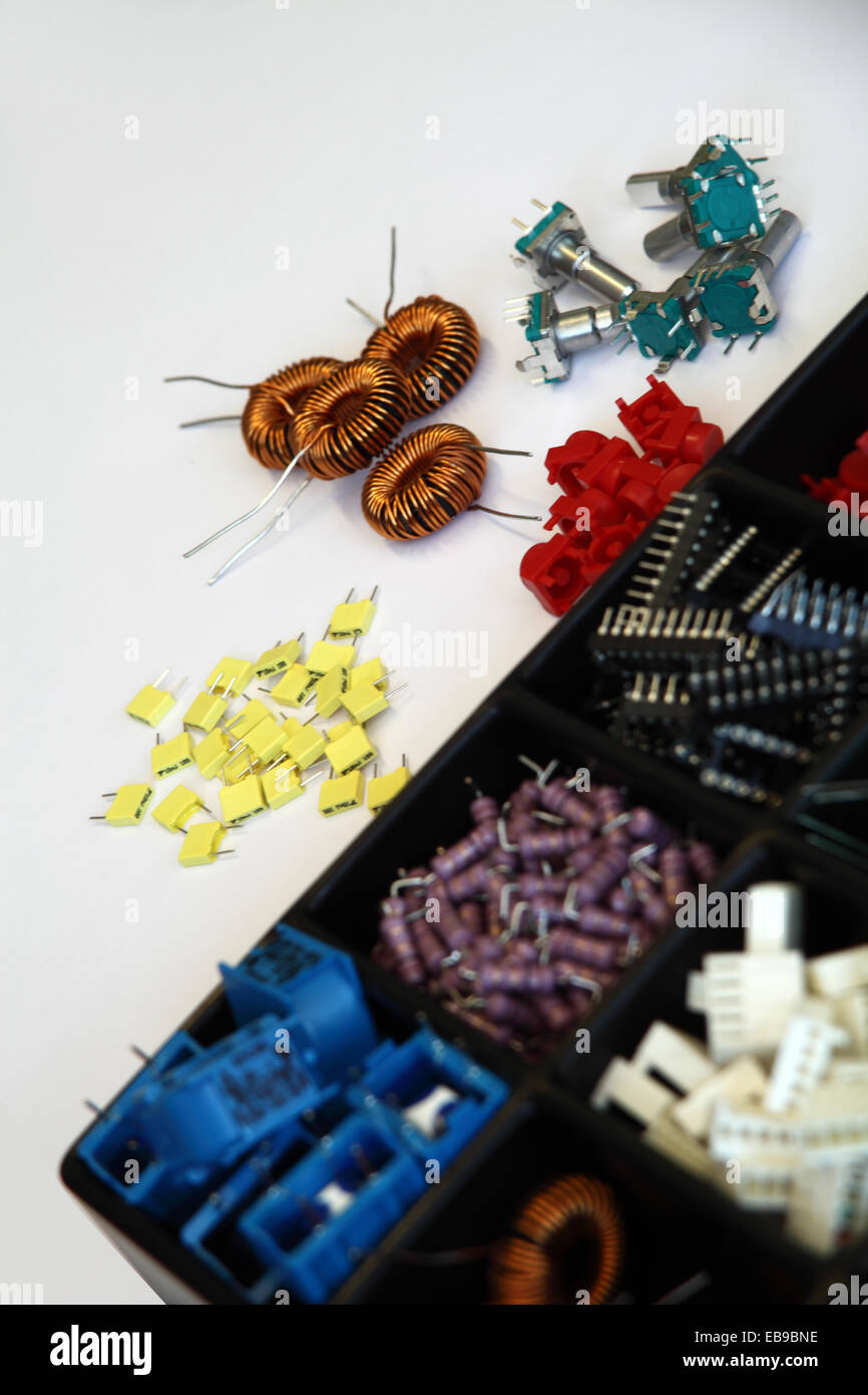 box with assortment of electronic components on a white background ...