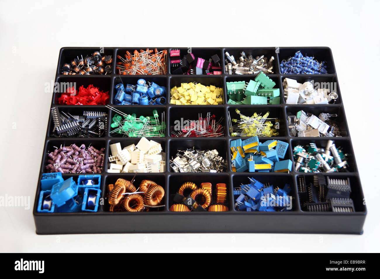 box with assortment of electronic components on a white background ...