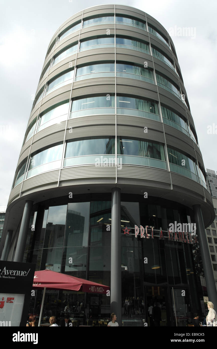 Sunny portrait circular office building with people at ground-floor ...