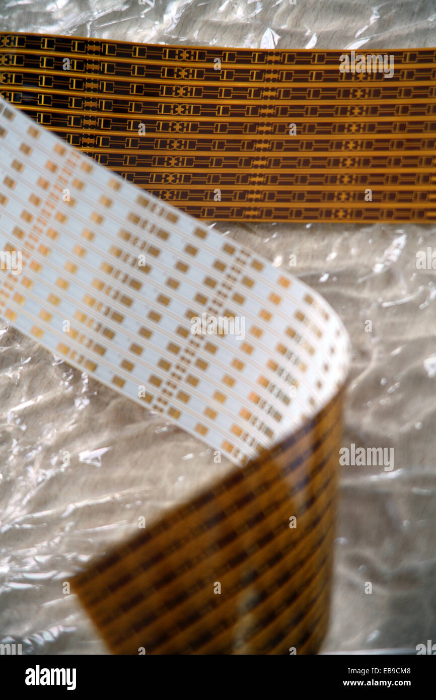 electronic contacts rolled strip on table Stock Photo - Alamy