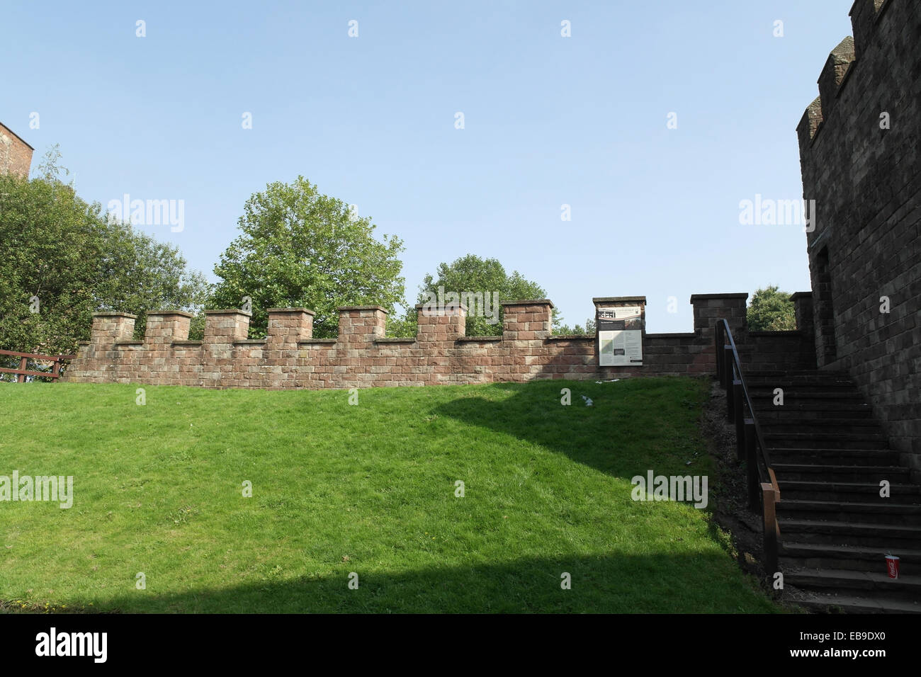 Blue sky view green grass rampart with stone wall battlements, side ...