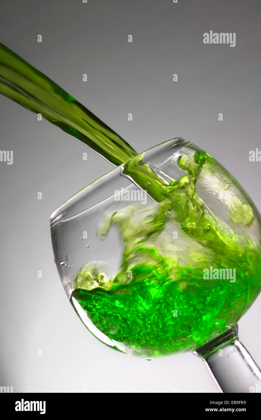 Green cocktail splash, glass with spilled liquid Stock Photo - Alamy