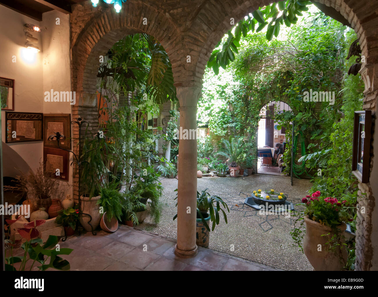 Typical interior Andalucian courtyard with plants, arches and pillars ...