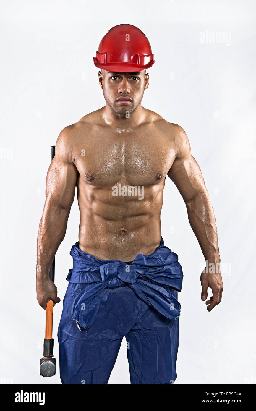 Young fit male shirtless workman holding sledgehammer wearing red ...