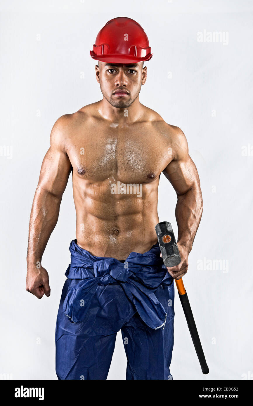Young fit male shirtless workman holding sledgehammer wearing red ...