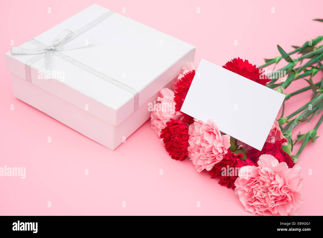 present box and carnations with a blank card ready for text Stock Photo ...