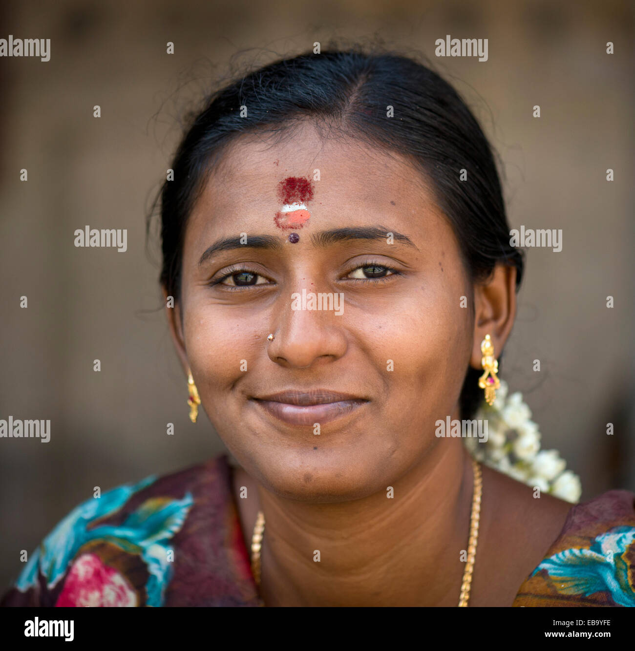 Woman with bindi on her forehead wearing gold ear rings, portrait ...