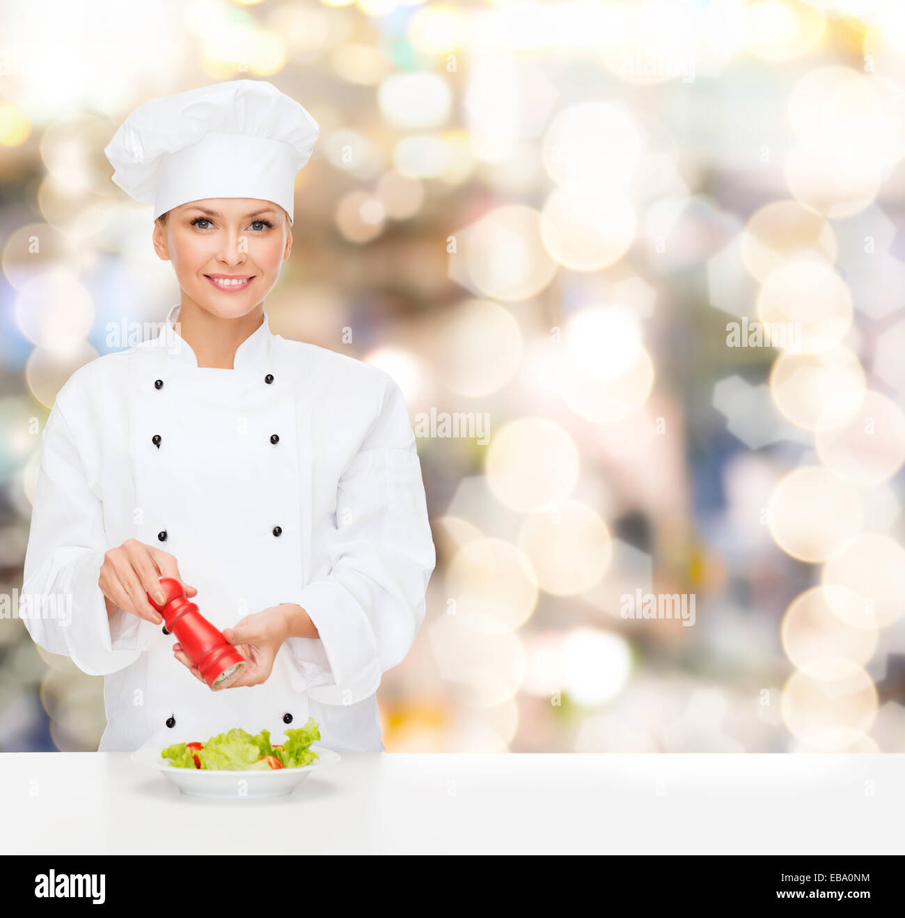 smiling female chef spicing vegetable salad Stock Photo - Alamy
