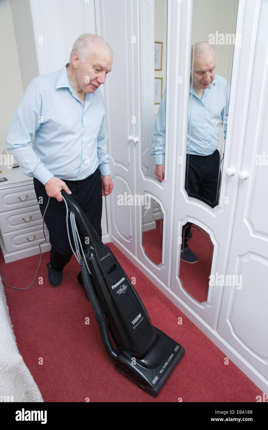 Older man hoovering in the bedroom Stock Photo - Alamy