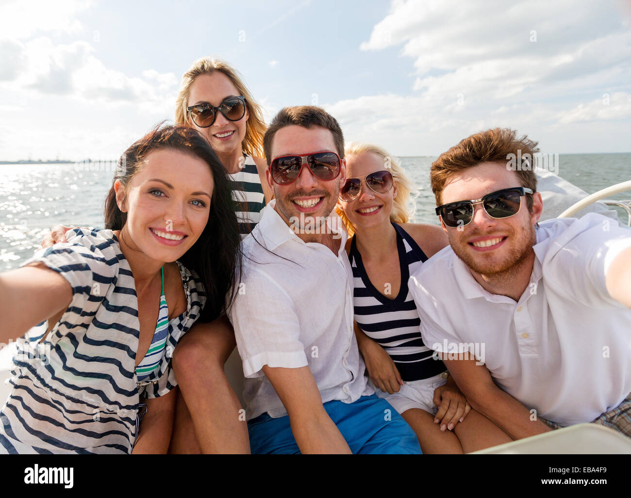 smiling friends sitting on yacht deck Stock Photo - Alamy