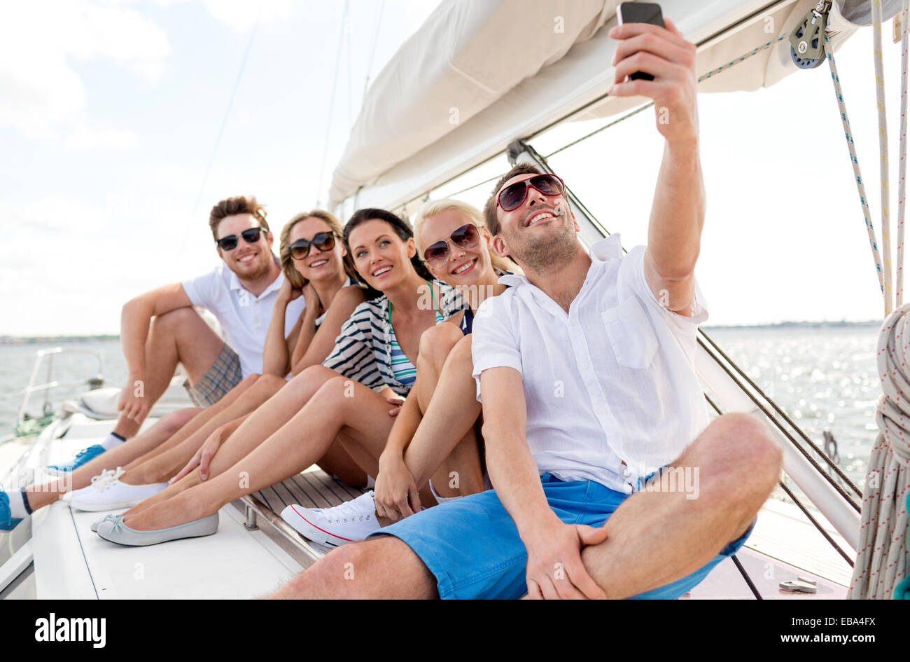 smiling friends sitting on yacht deck Stock Photo - Alamy