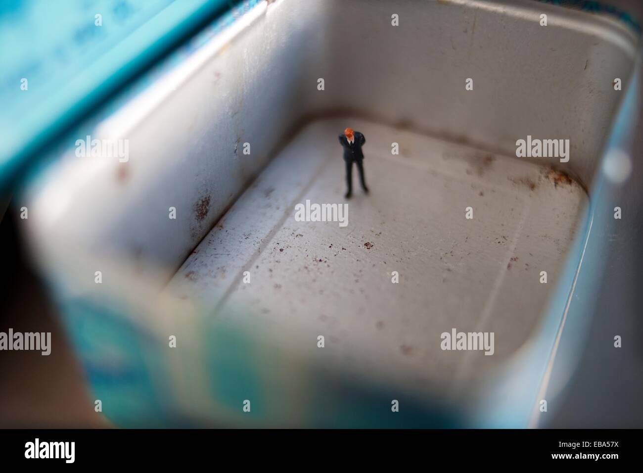 Figure of executive inside tin box Stock Photo - Alamy