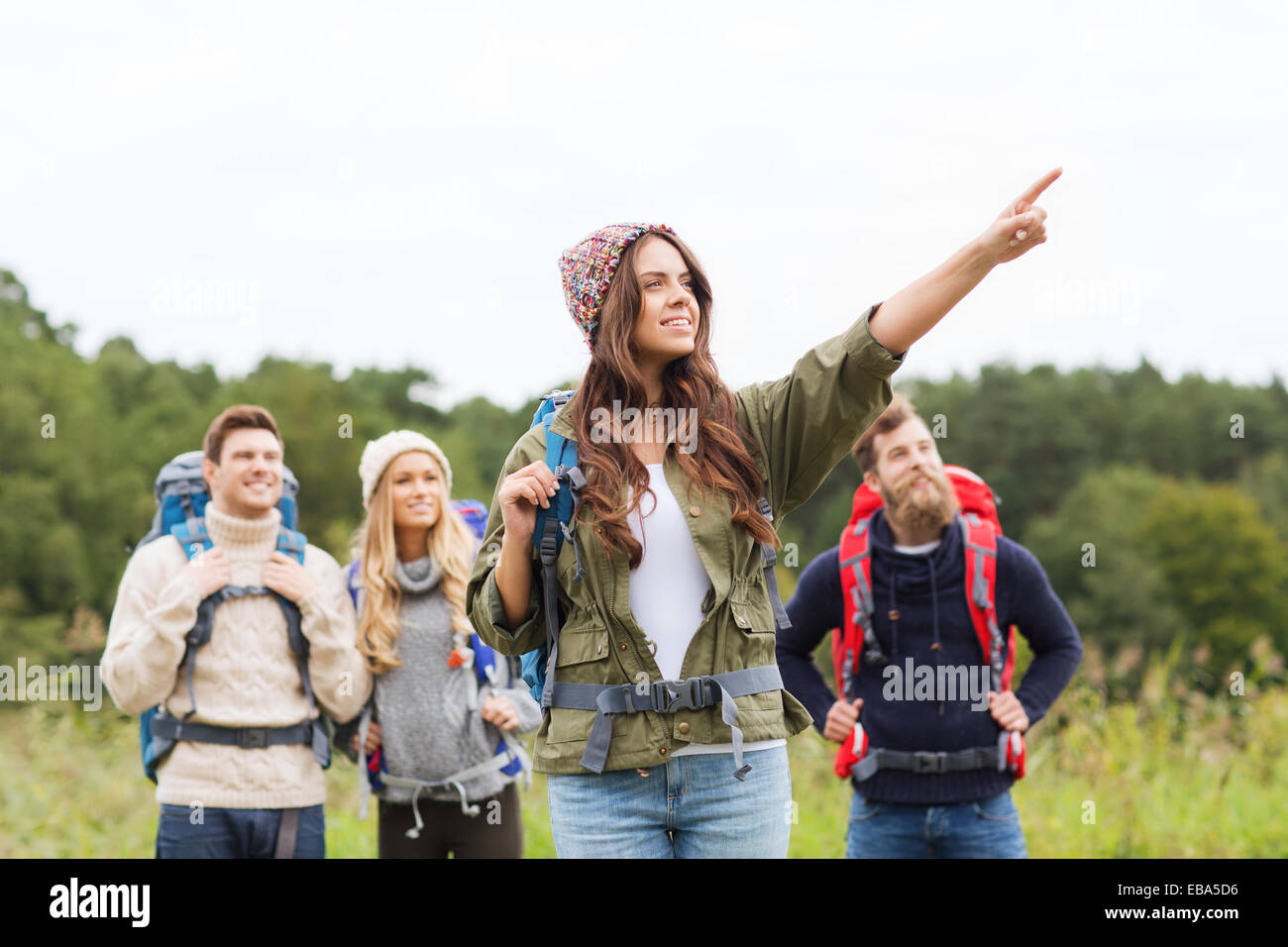 smiling hikers with backpacks pointing finger Stock Photo - Alamy