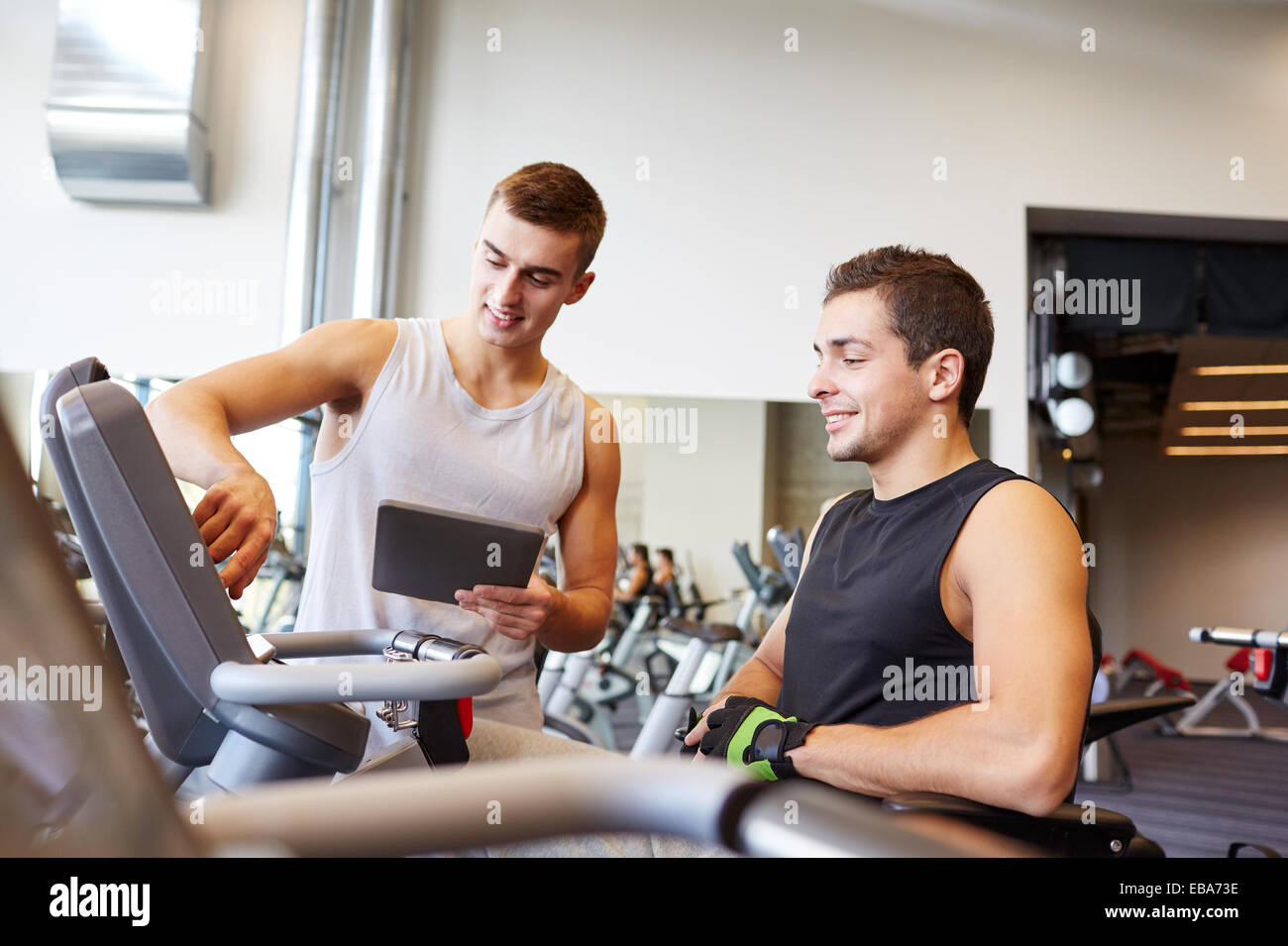 men exercising on gym machine Stock Photo - Alamy
