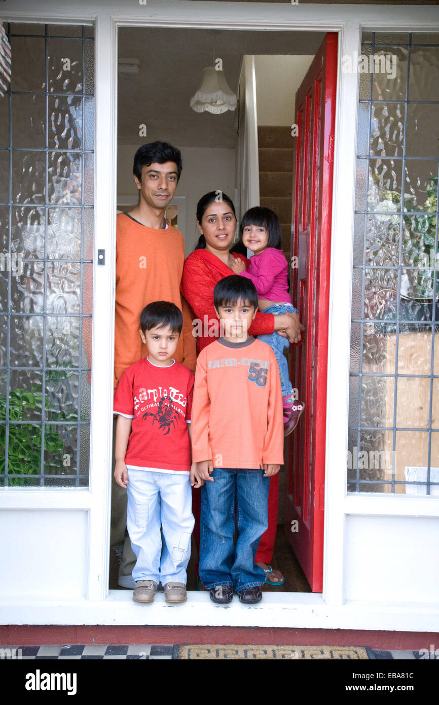 Young family standing outside their front door Stock Photo - Alamy