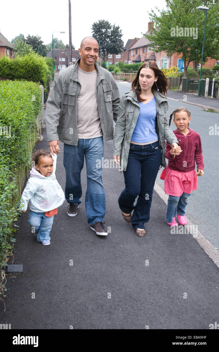 Young family walking down the street together Stock Photo - Alamy