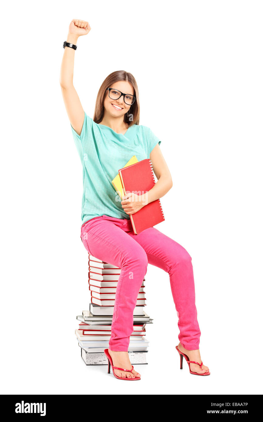 Happy female student sitting on a stack of books isolated on white ...