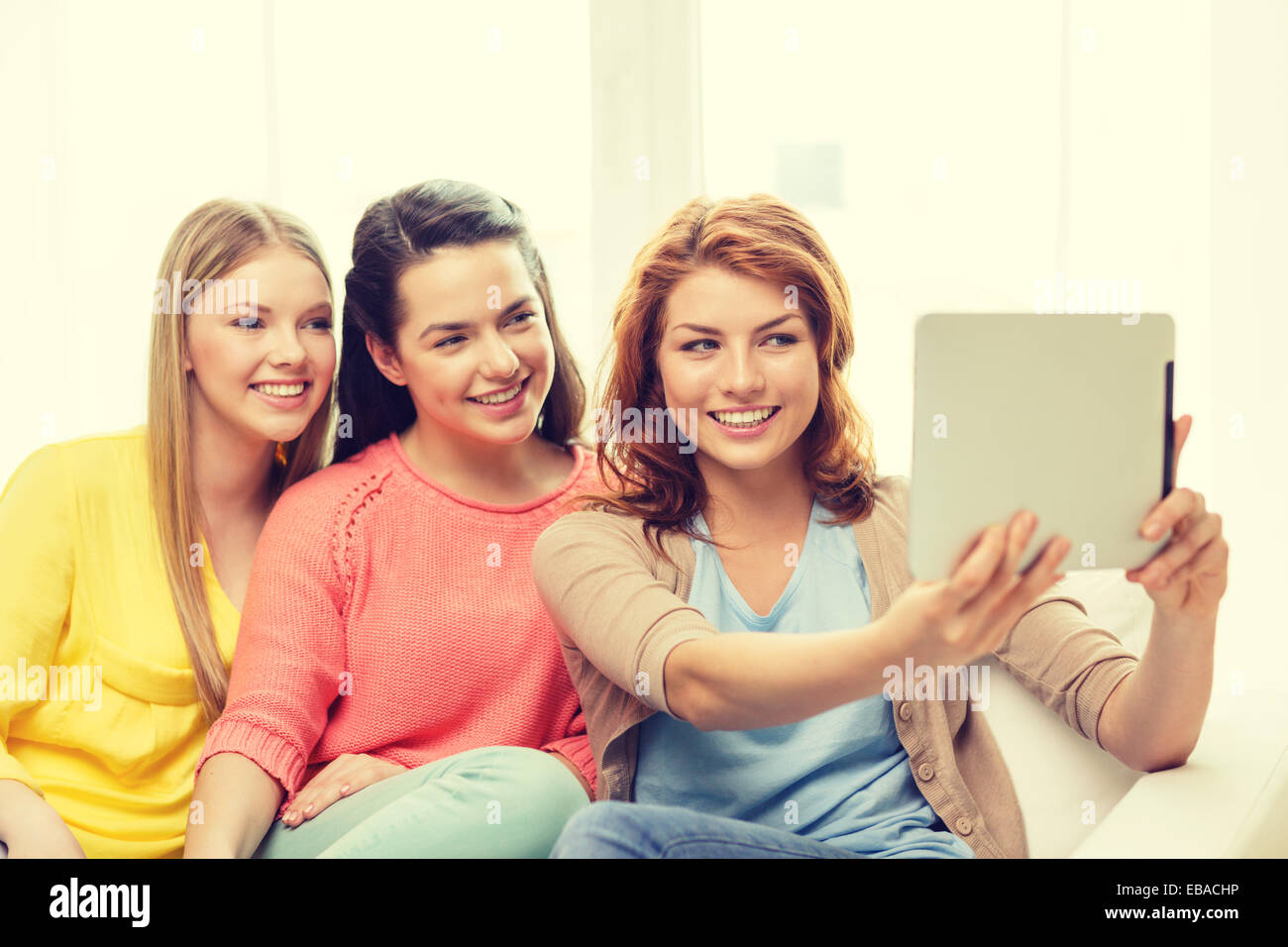 three smiling teenage girls with tablet pc at home Stock Photo - Alamy