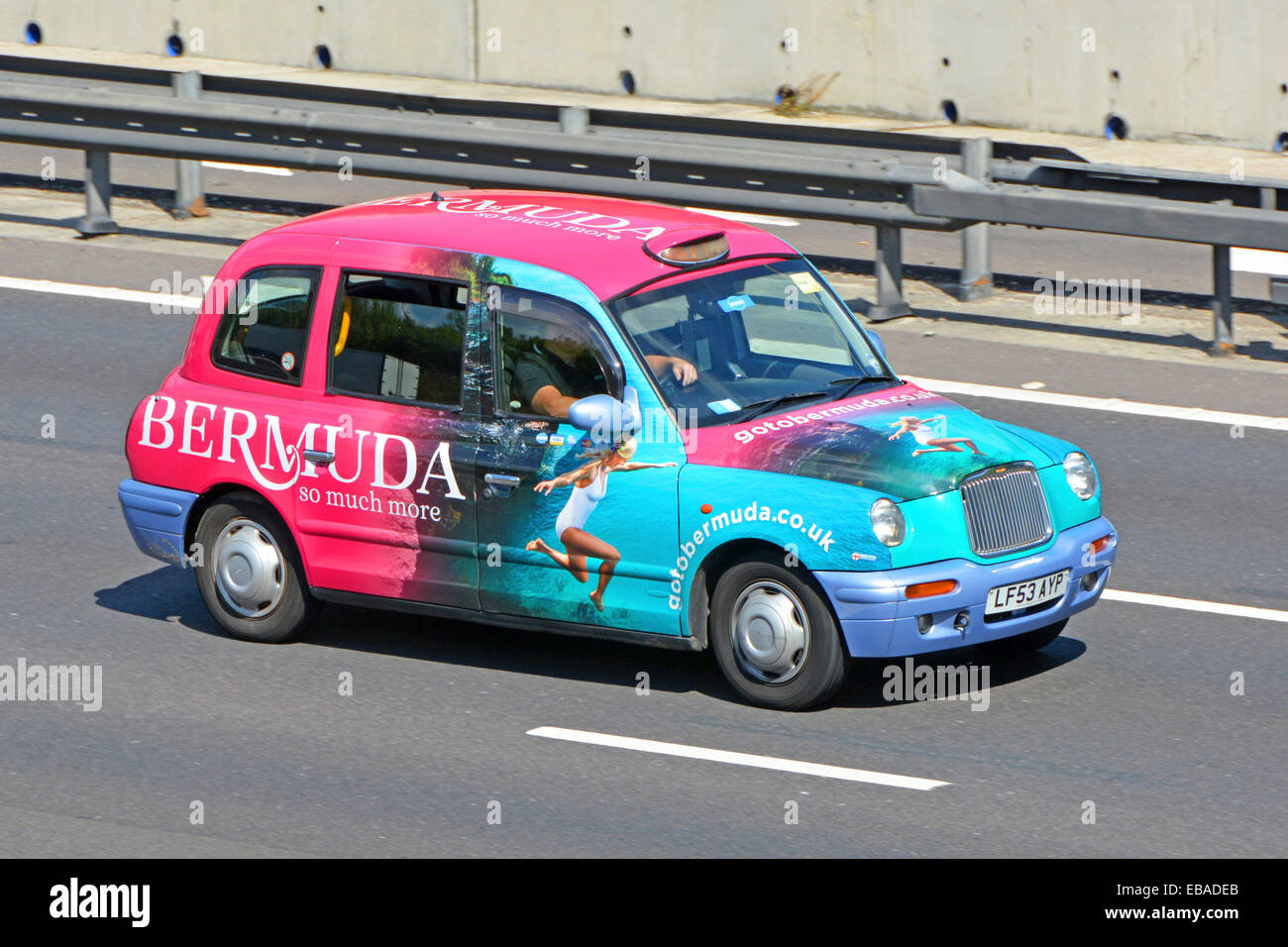 London taxi cab driving along motorway, vehicle covered in Bermuda ...