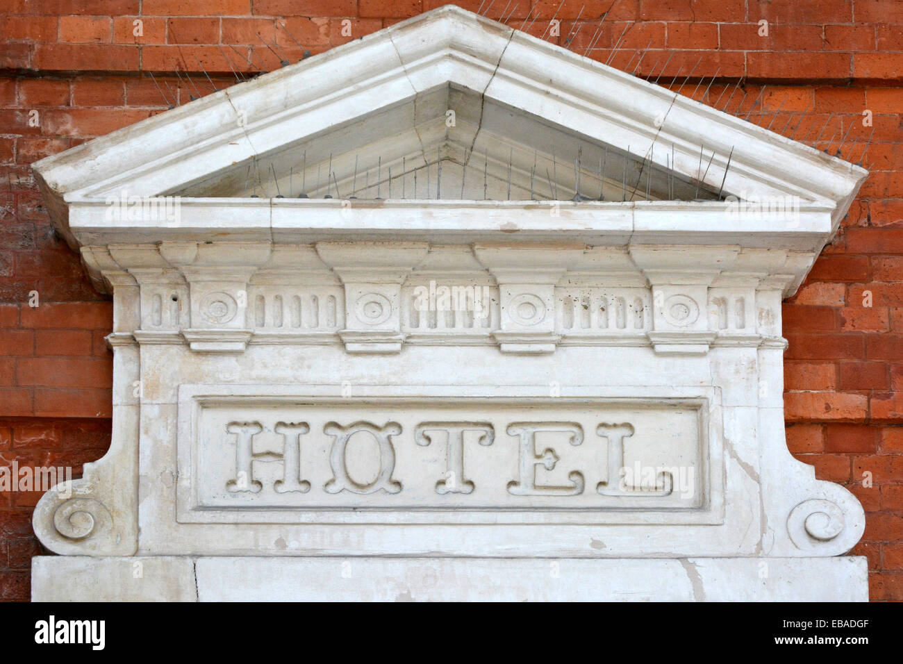 The word Hotel carved into an old stone sign mounted on a brick wall ...