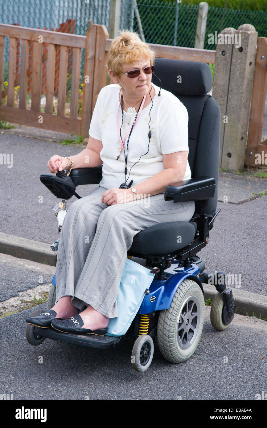 Female wheelchair user checking for oncoming traffic before crossing a ...