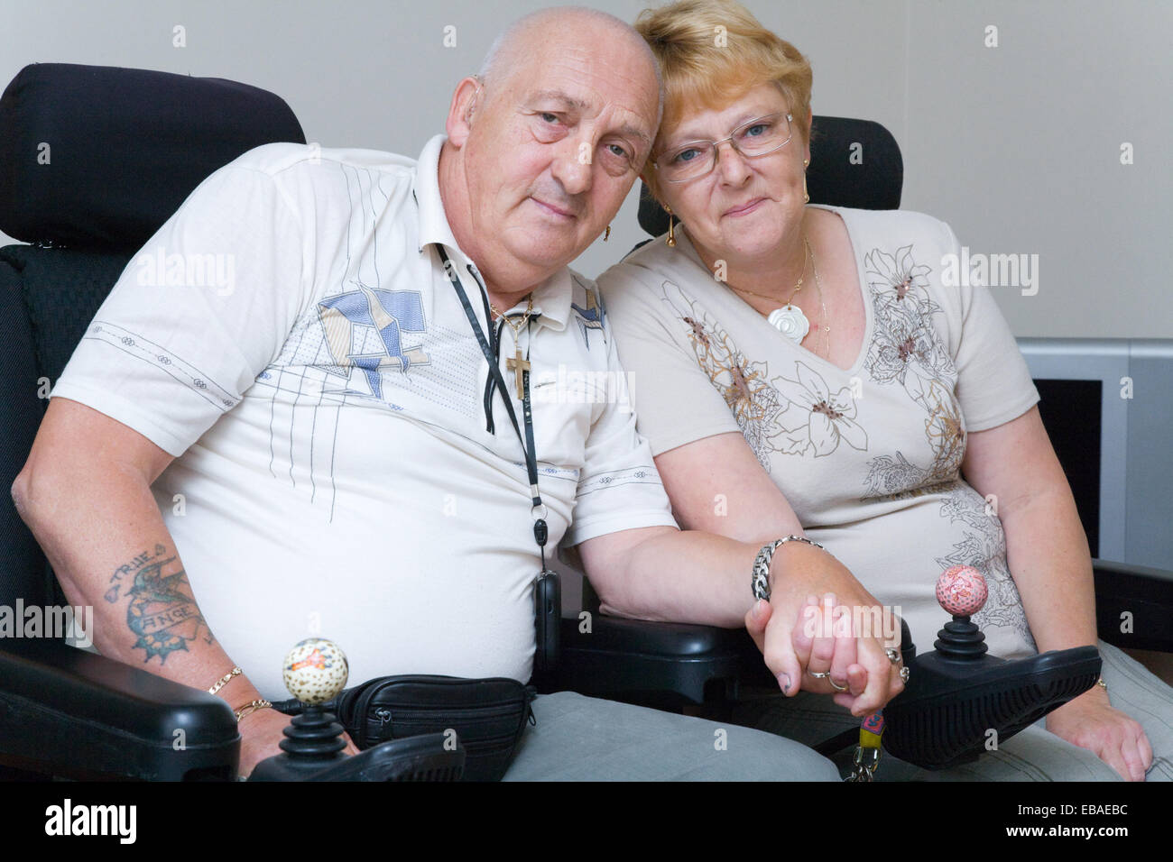 Disabled couple at home holding hands with one another Stock Photo - Alamy