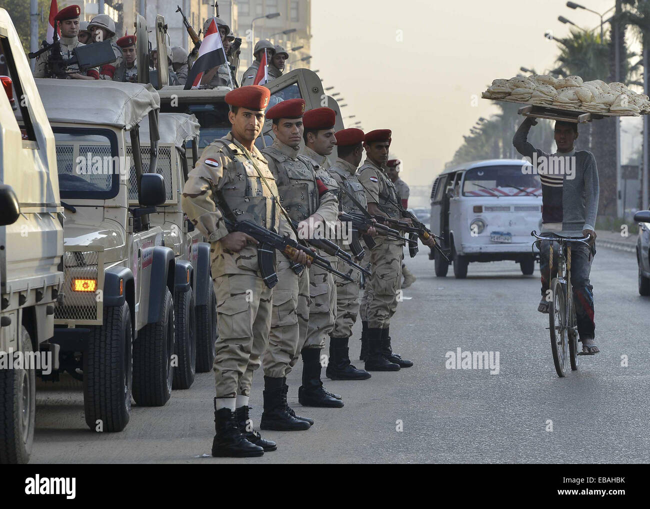 Cairo, Egypt. 28th Nov, 2014. Egyptian security forces stand guard in front of armored vehicles ...