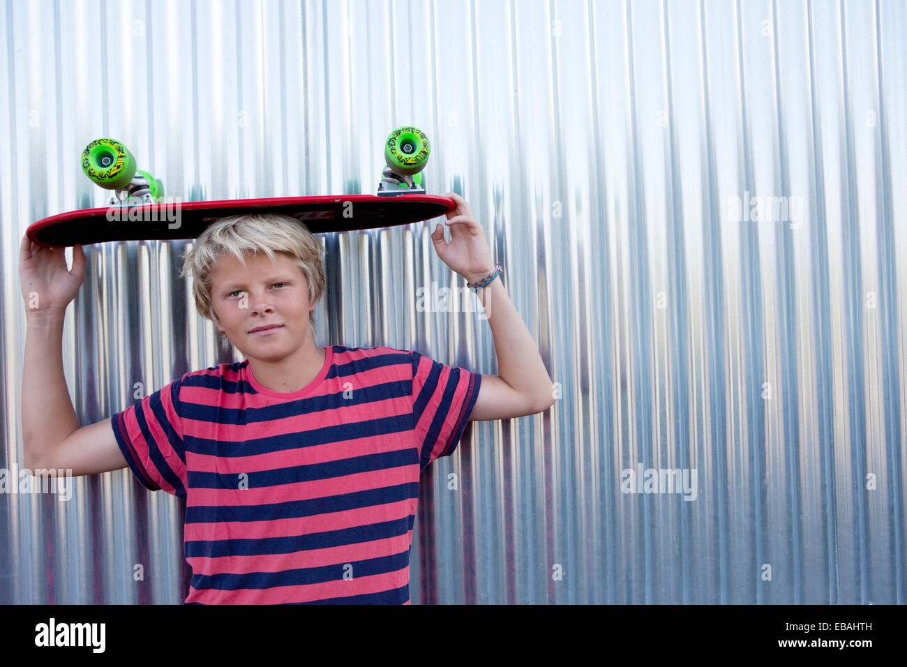 Teenage boy holding a longboard on his head Stock Photo - Alamy