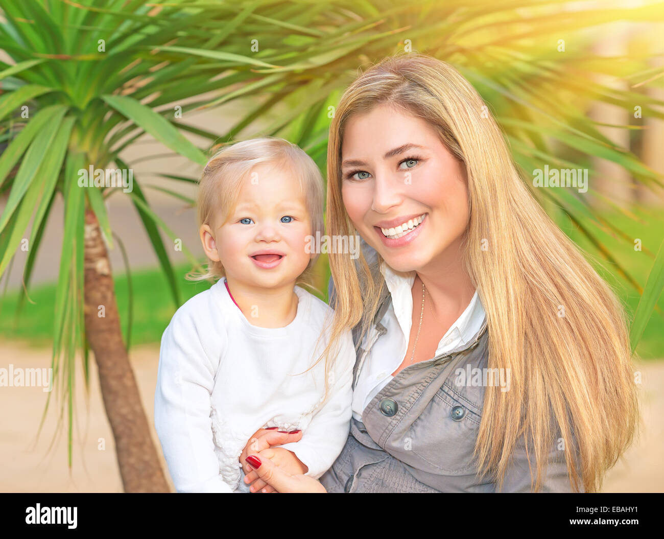 Happy family portrait, cute smiling mother holding on hands her little ...
