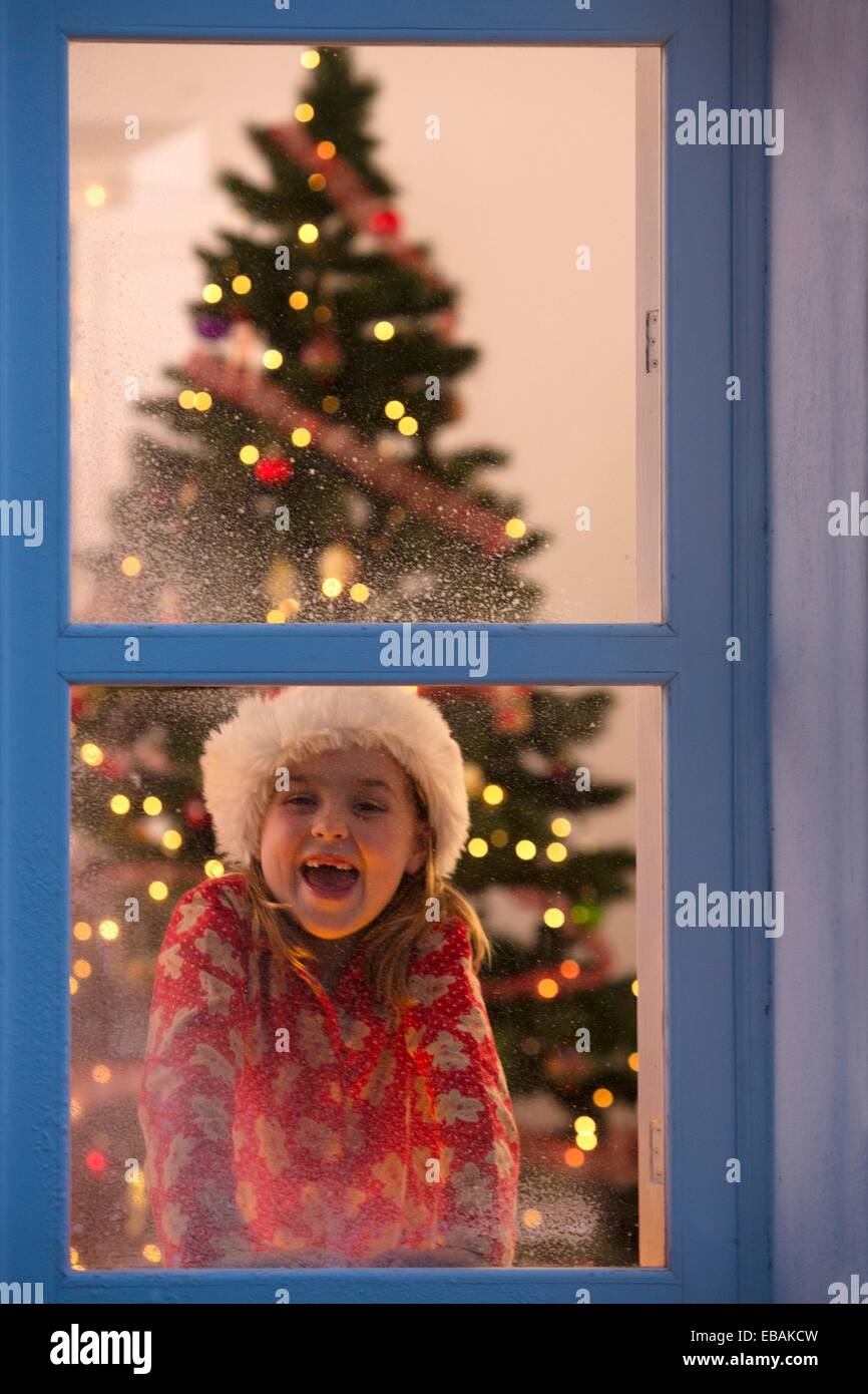 Young girl looking out of the window waiting for Santa to arrive Stock ...