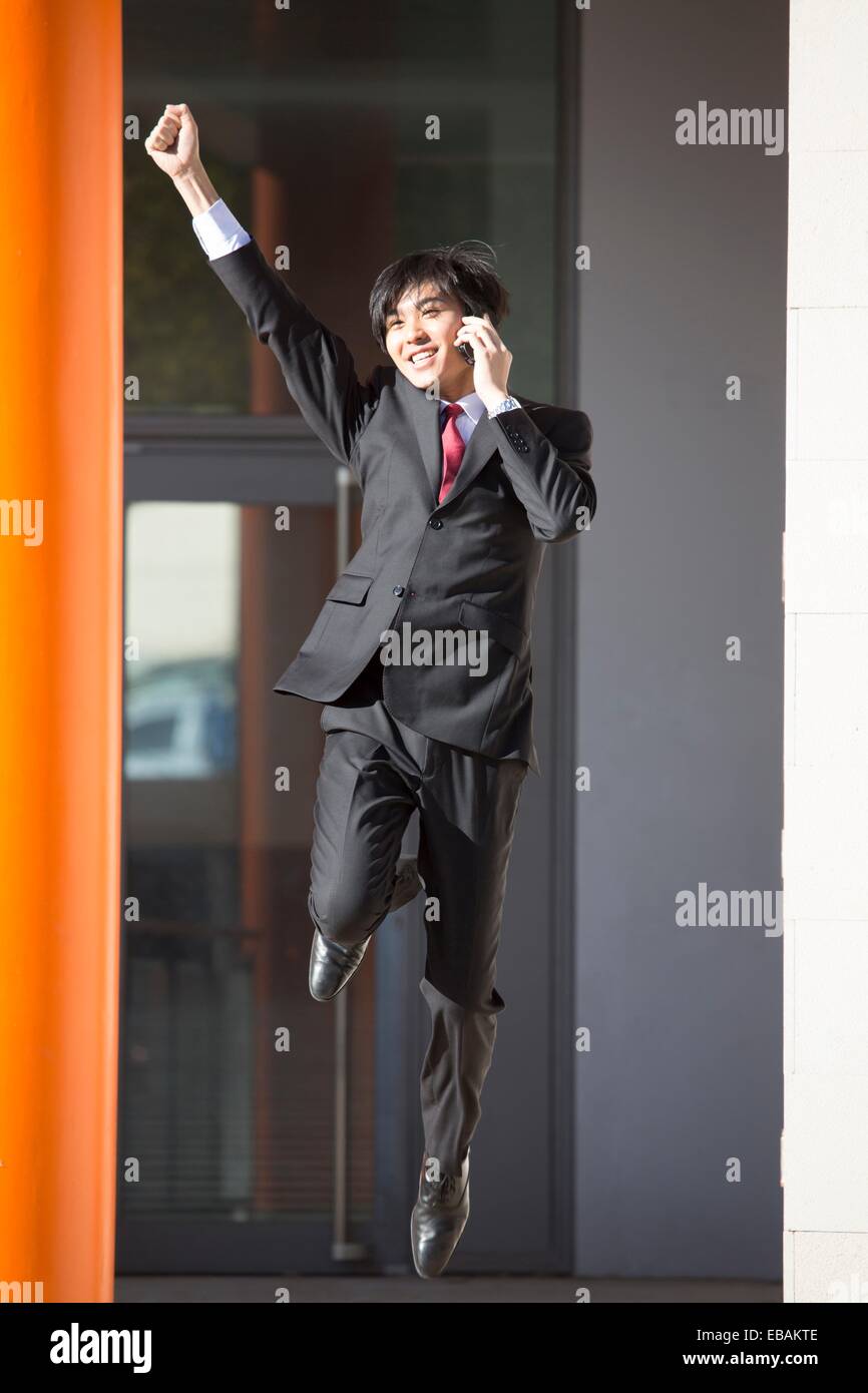 Young Asian businessman jumping for joy Stock Photo - Alamy