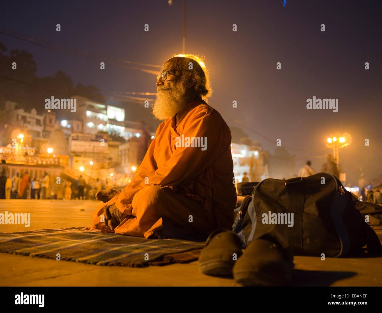 Pilgrim meditates during “Arti” evening prayers on the ghats on the ...