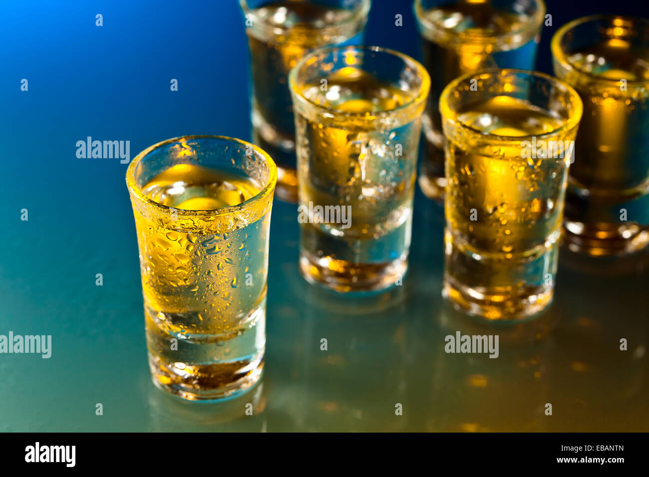Glasses with an alcoholic drink on a glass table Stock Photo - Alamy