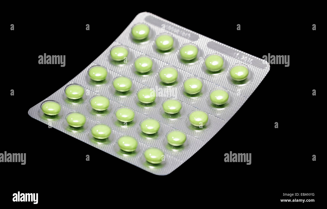 green pills isolated on a black background Stock Photo - Alamy