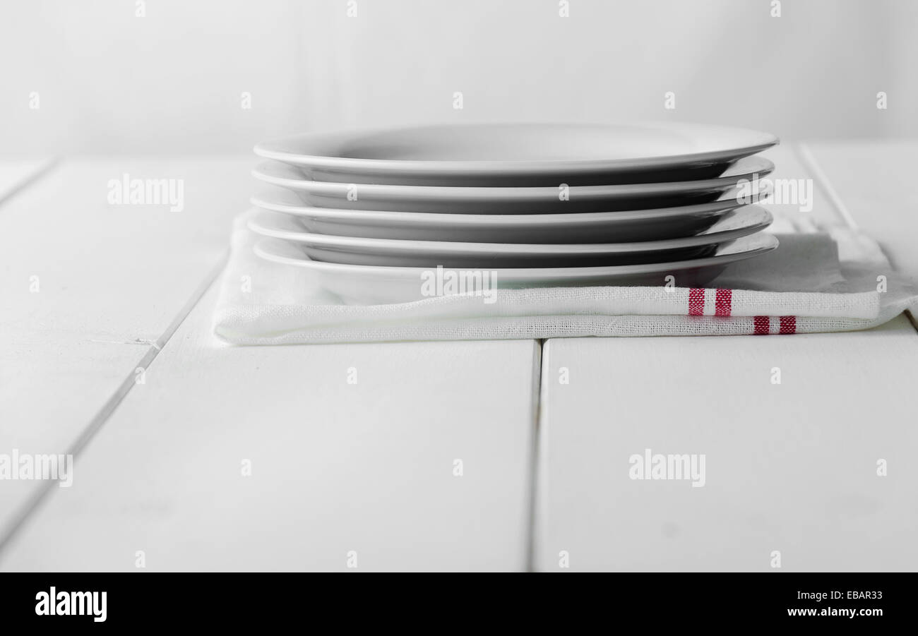 Empty stack of dishes over white wooden table Stock Photo - Alamy