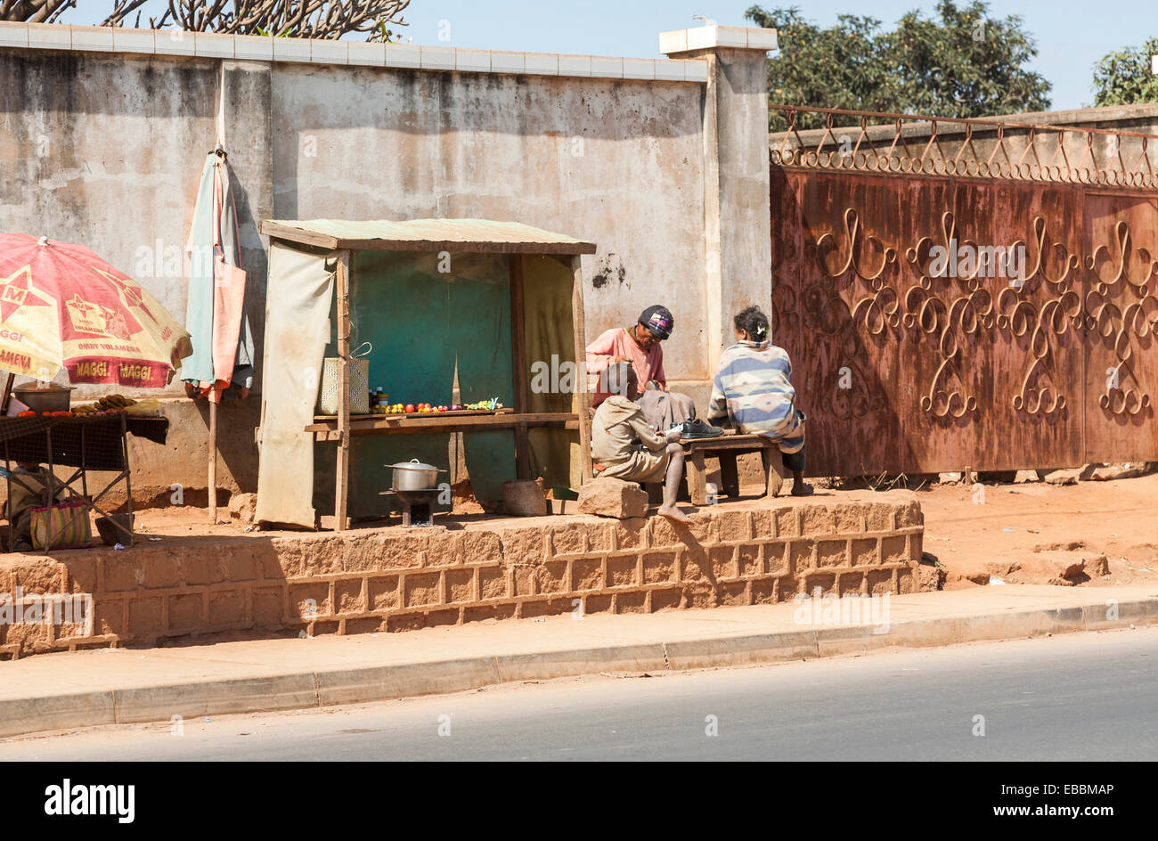 Local family tending a small pavement roadside stall mending shoes and ...