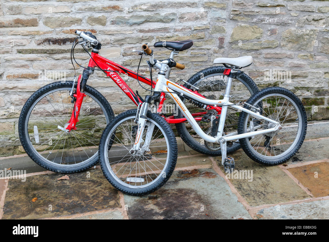 Childrens bikes leaning against a wall Stock Photo - Alamy