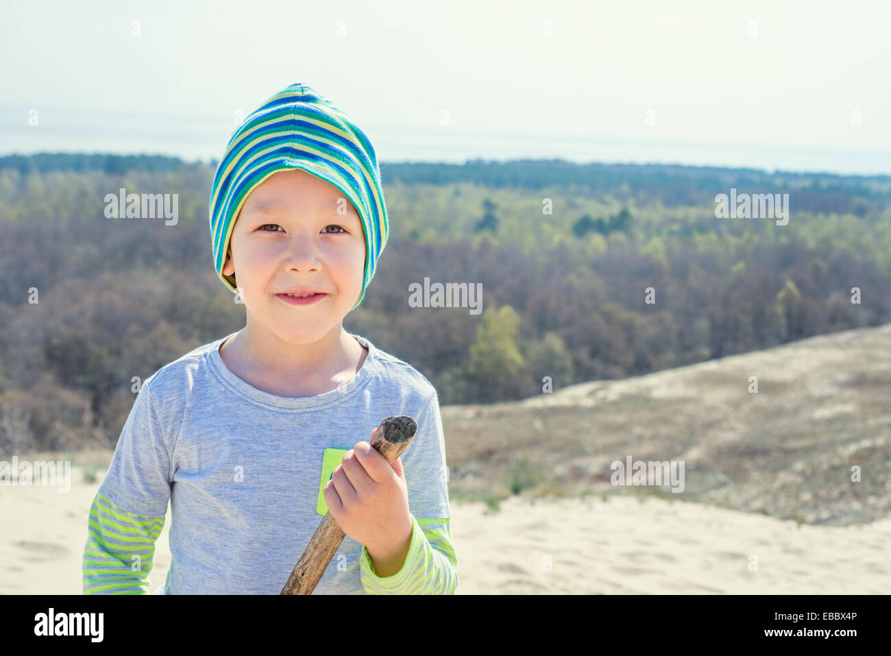Boy with a stick walks on nature Stock Photo - Alamy