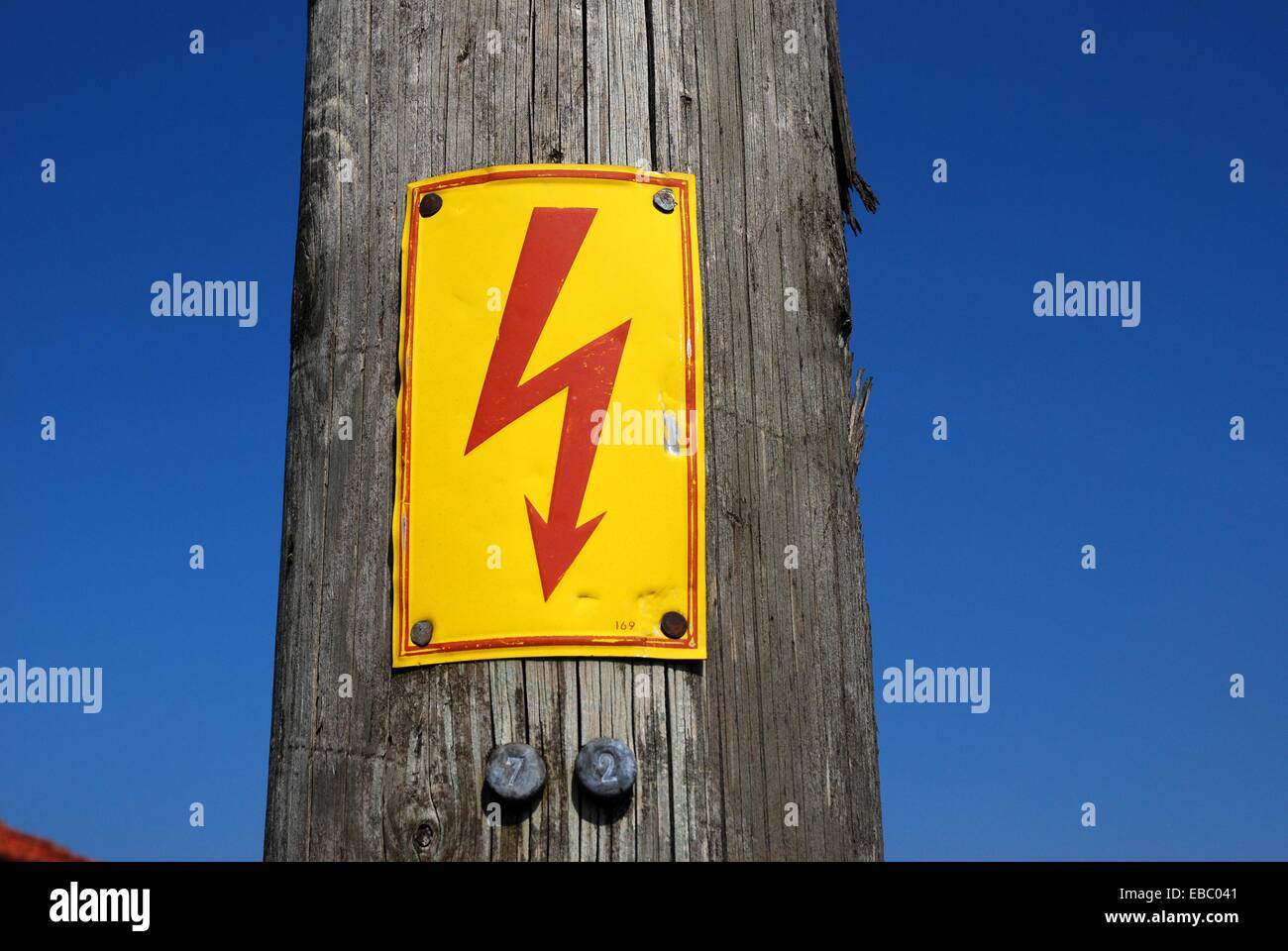 Warning sign caution electrical power to a utility pole Stock Photo - Alamy