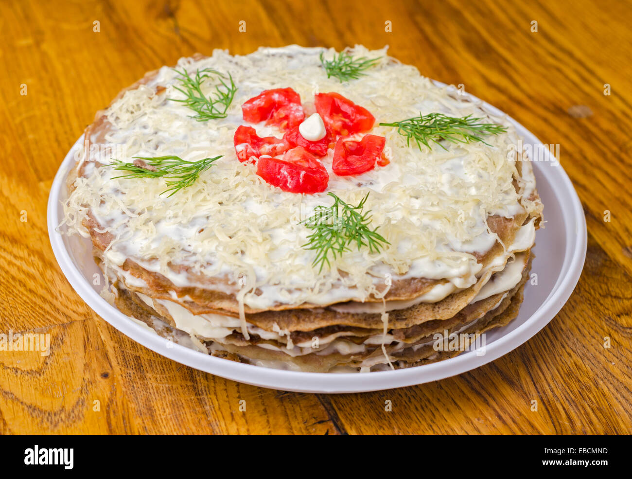 Liver cake with garlic, dill sauce and tomatoes in the white plate on ...