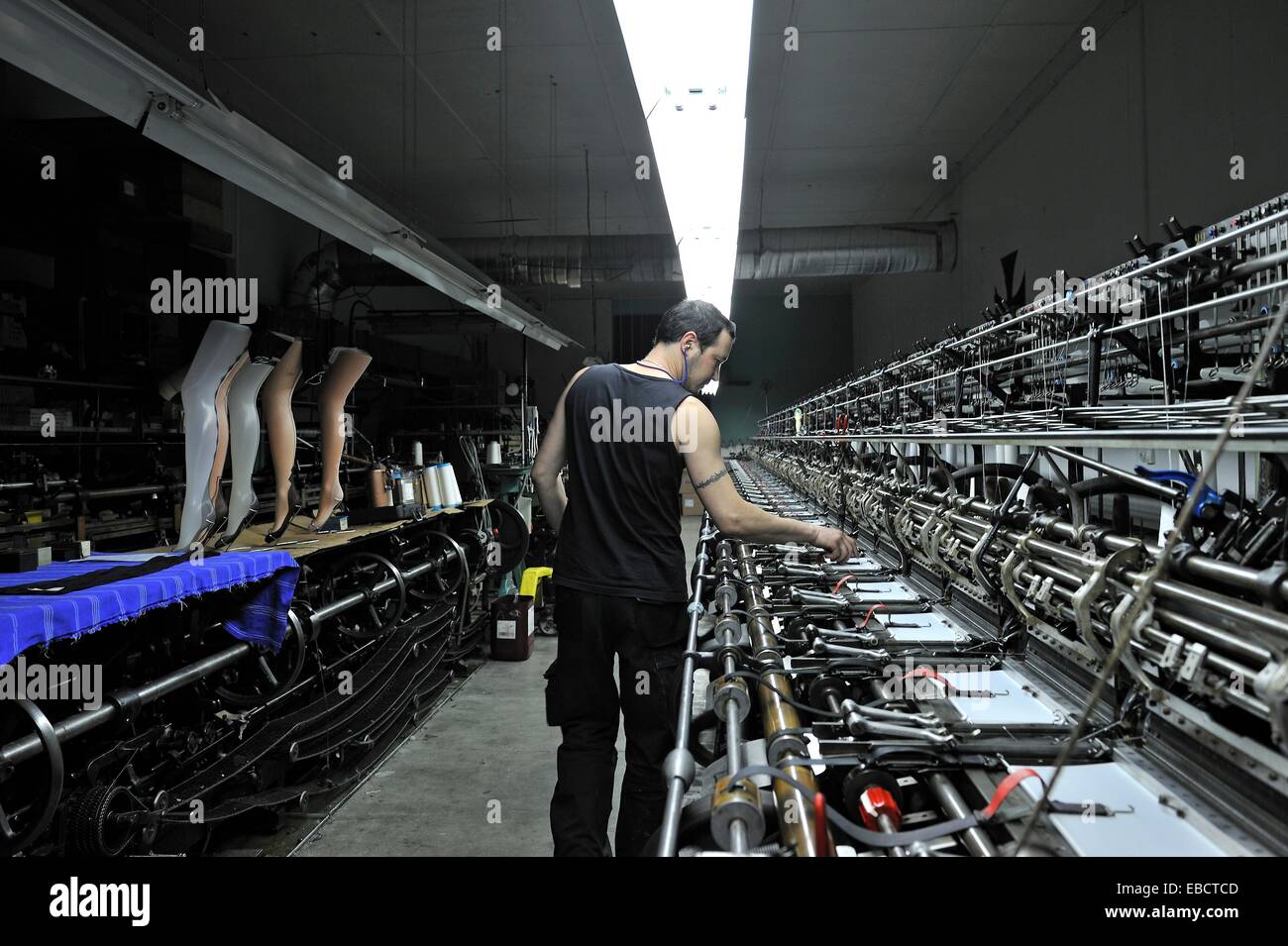 skilled worker in charge of the old weaving looms in the luxury silk ...