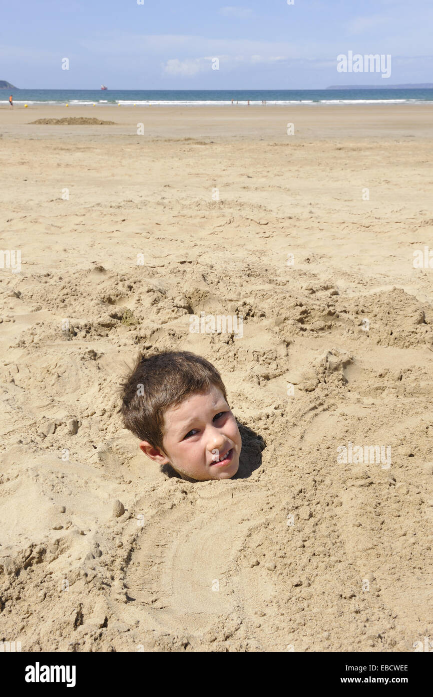 Boy buried in sand on hi-res stock photography and images - Alamy