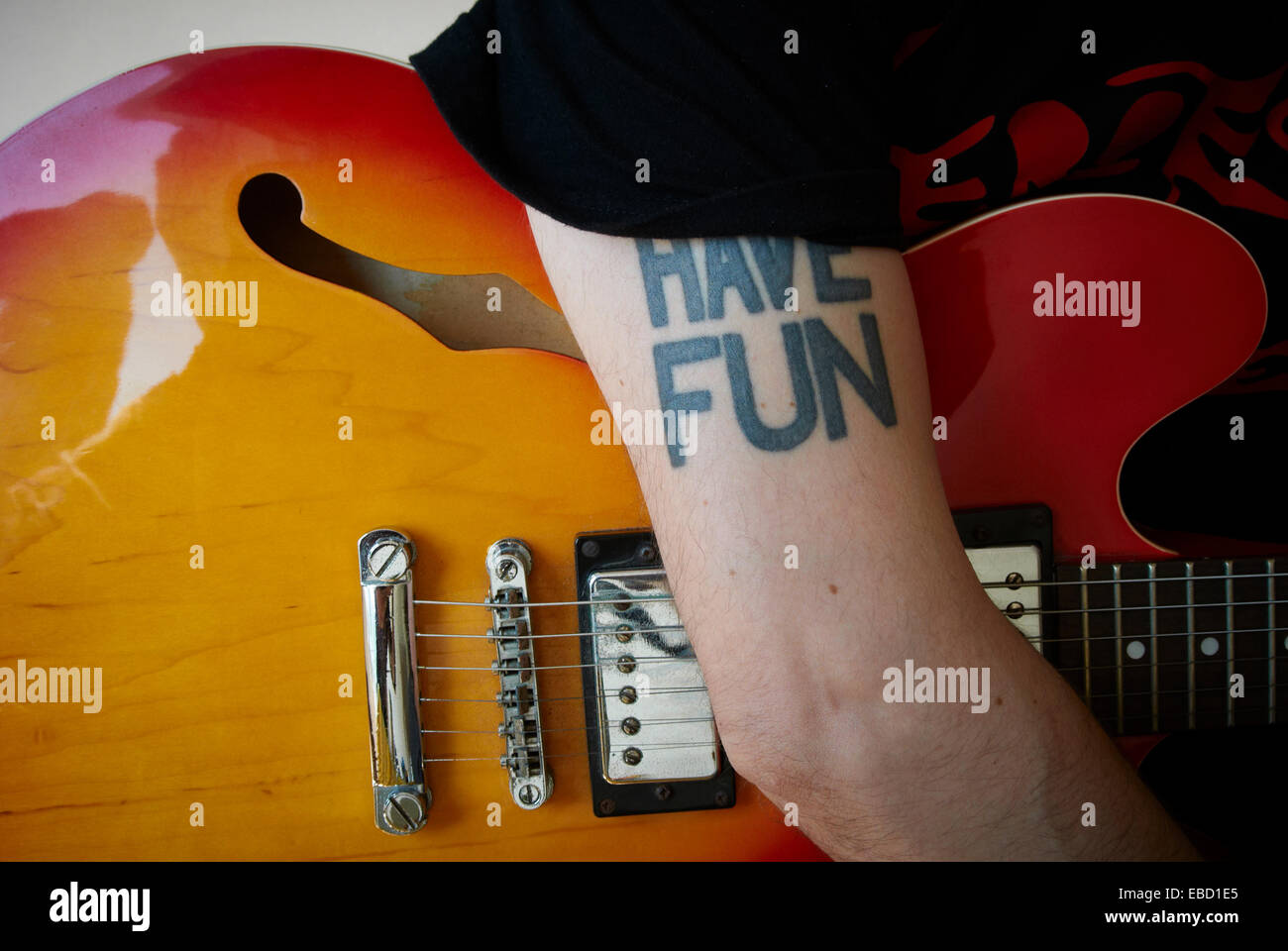 Guitarist musician with tattoo Have Fun inscribed on his arm Stock ...